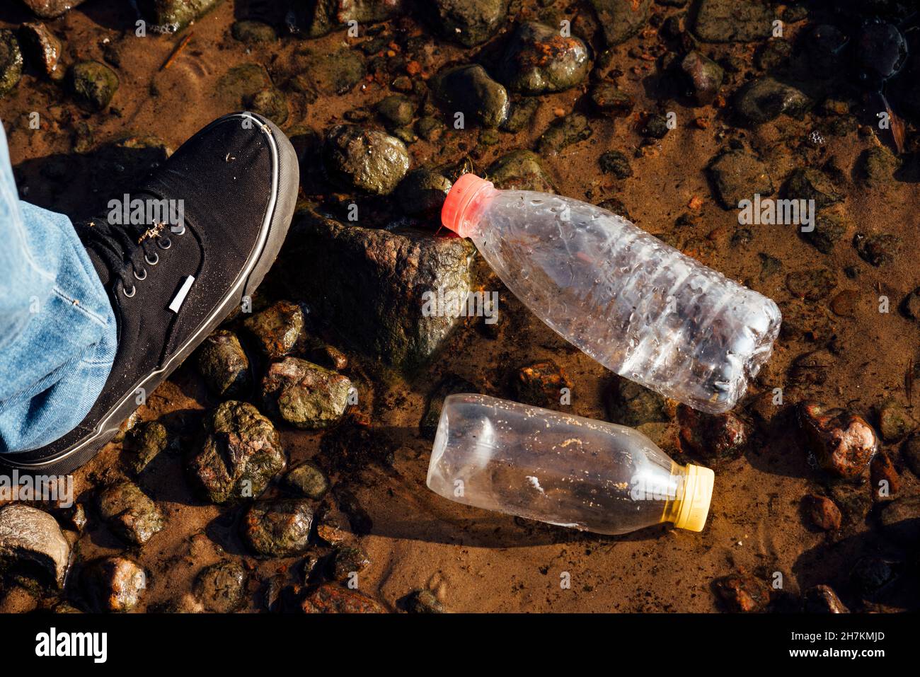 Plastic bottles floating on water by man Stock Photo - Alamy