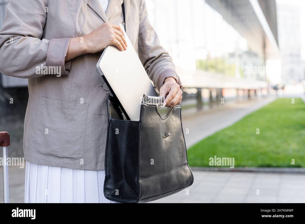 Female professional putting laptop in bag Stock Photo - Alamy