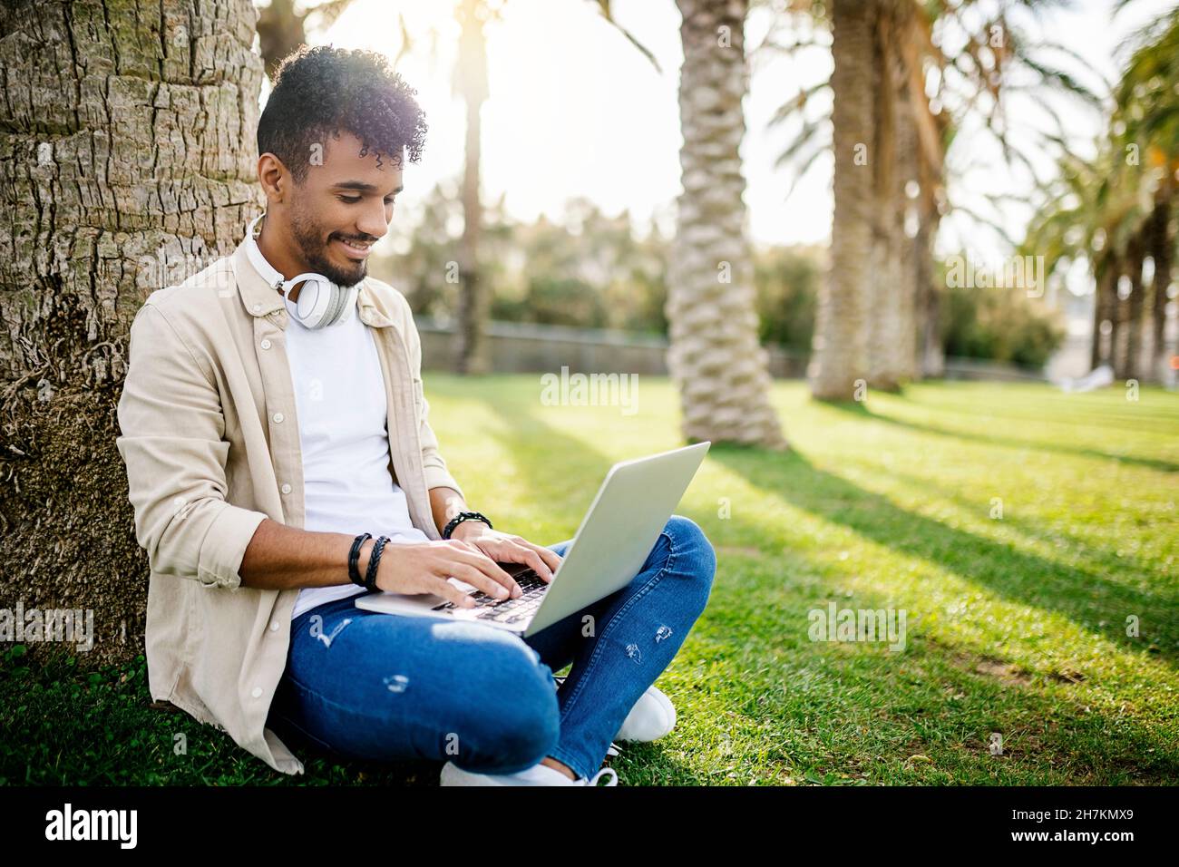 Man sitting by tree using laptop hi-res stock photography and images ...