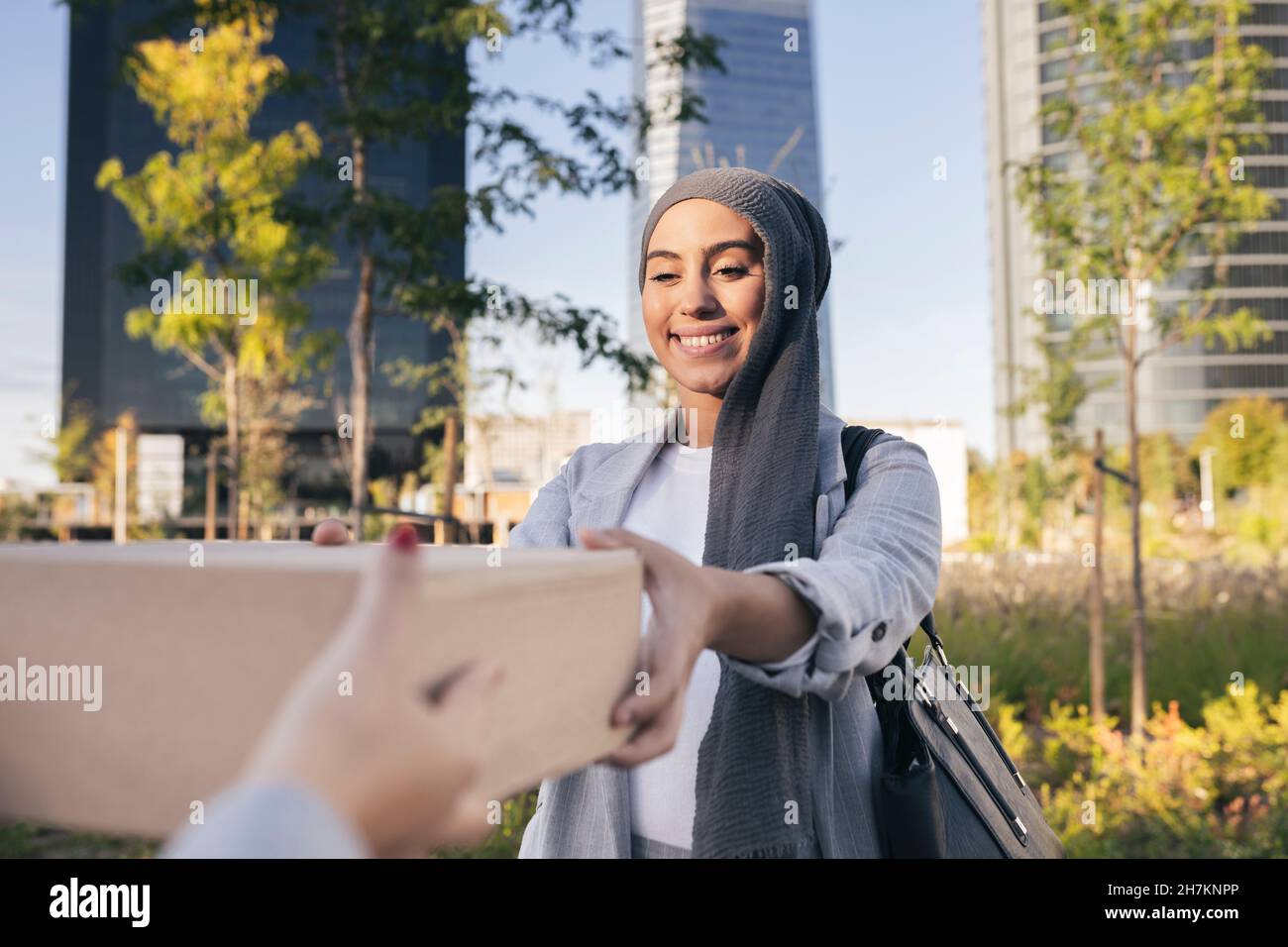 Happy female professional receiving box from friend Stock Photo - Alamy