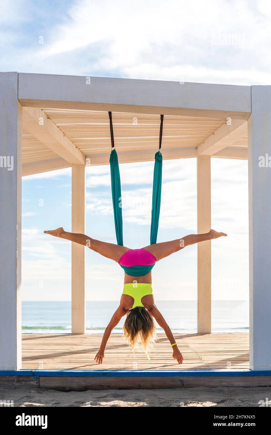 Female acrobat doing splits under shade at beach Stock Photo - Alamy