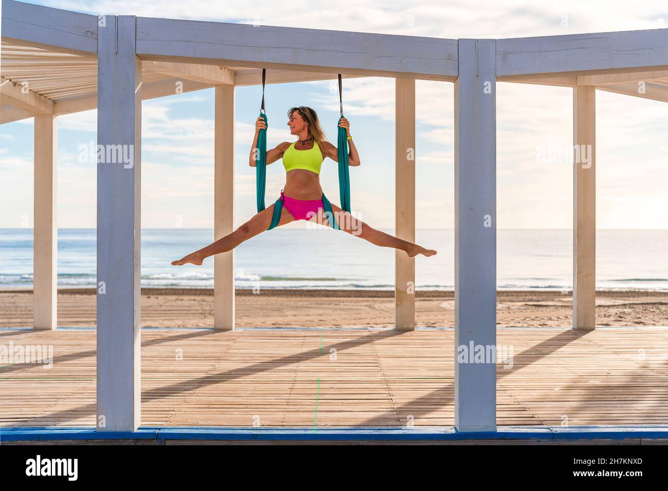 Female acrobat hanging during sunny day Stock Photo - Alamy