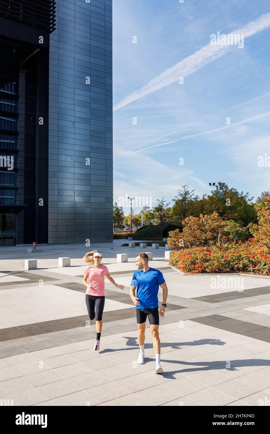 Male and female athletes running on footpath Stock Photo - Alamy
