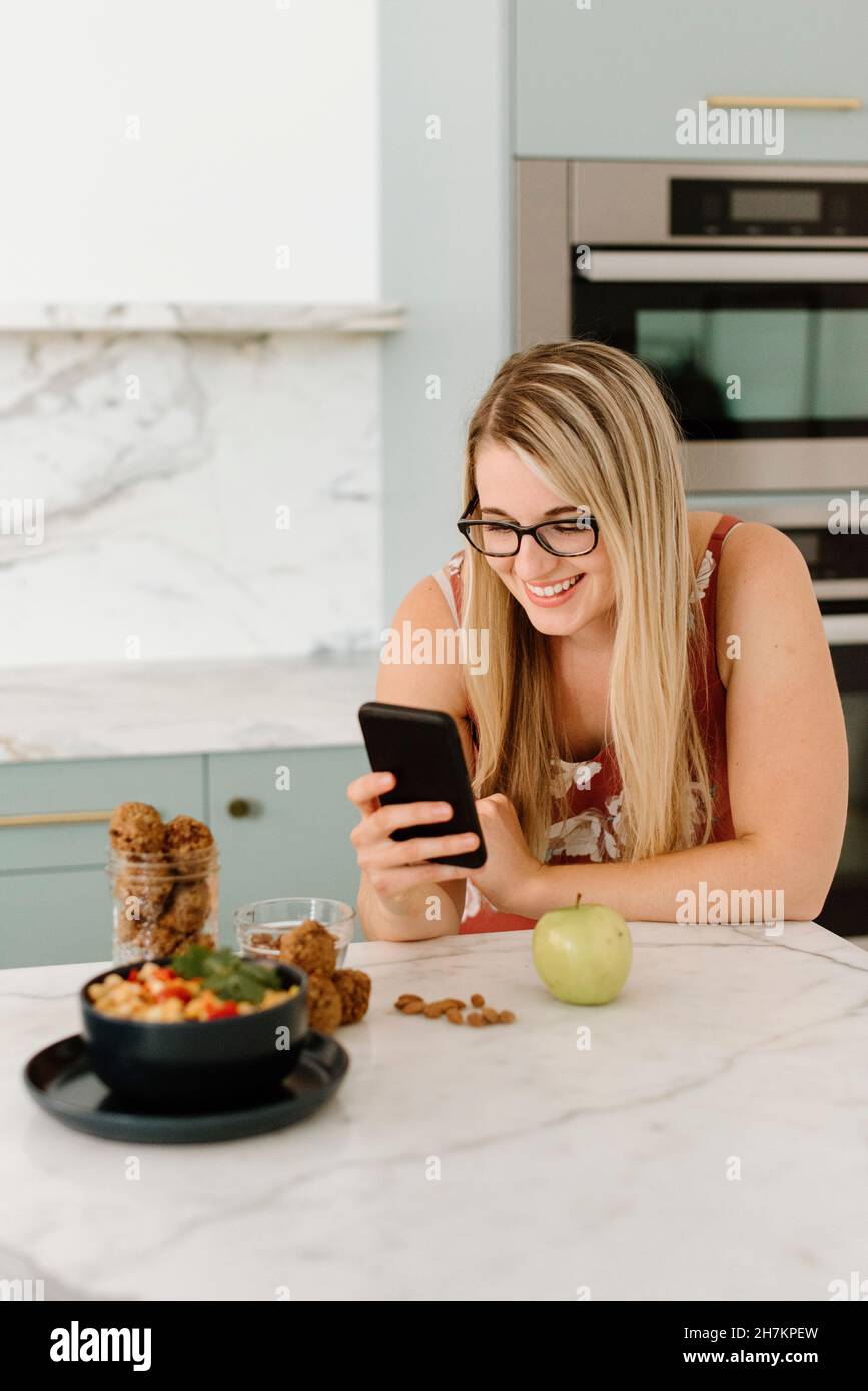 Female nutrient expert photographing food through mobile phone in ...