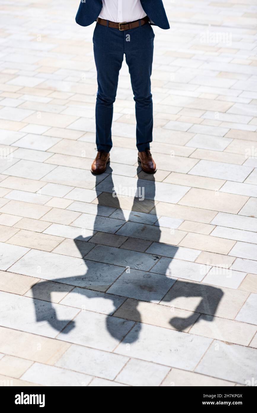 Shadow of businessman flexing muscles on sunny day Stock Photo - Alamy