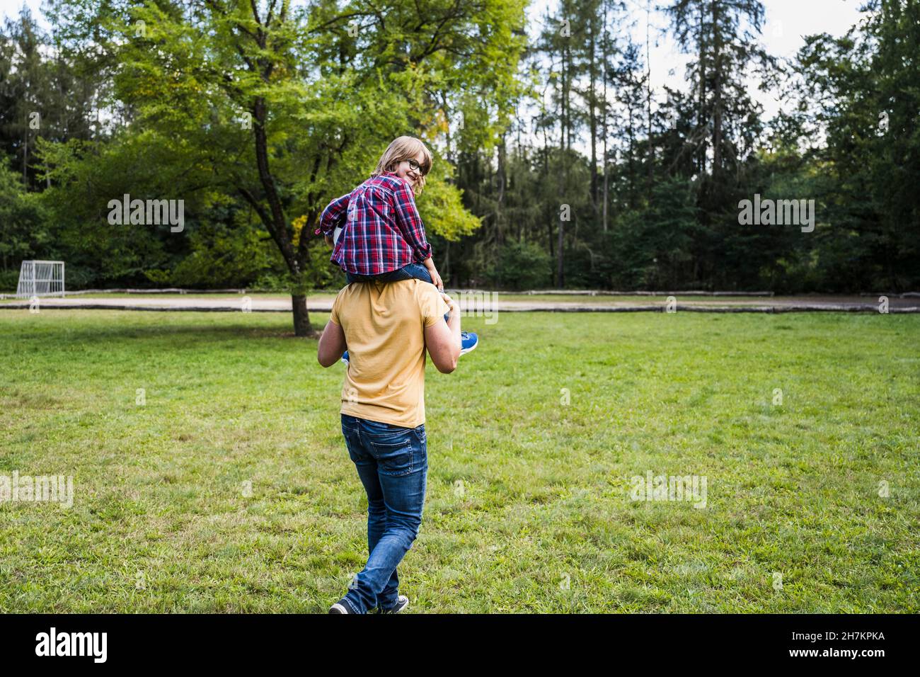 Playful man carrying boy on shoulders in park Stock Photo - Alamy