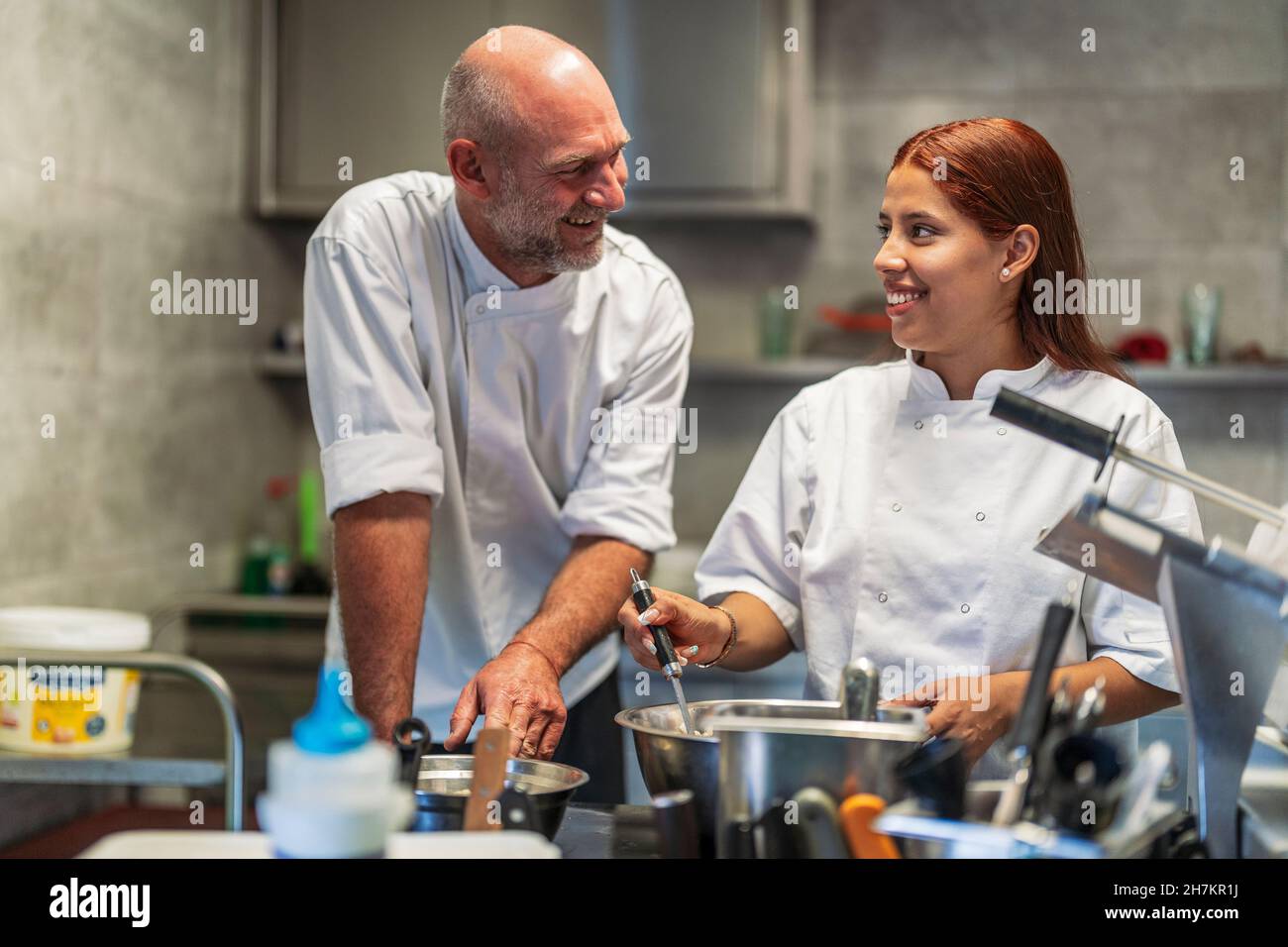 Smiling male and female chefs talking while cooking in kitchen Stock ...