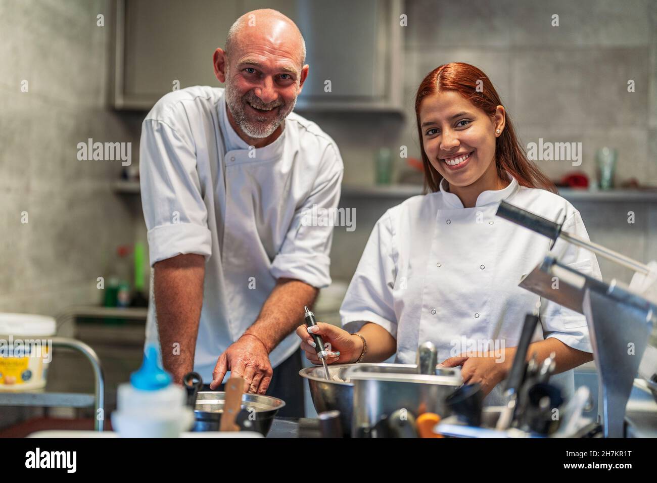 Smiling male and female chefs working in kitchen Stock Photo - Alamy