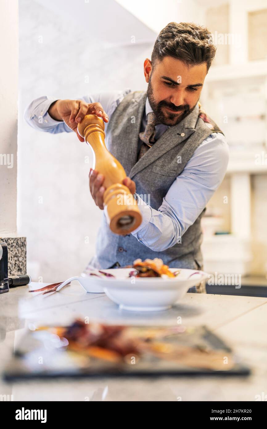Male chef seasoning pepper on food in restaurant Stock Photo - Alamy