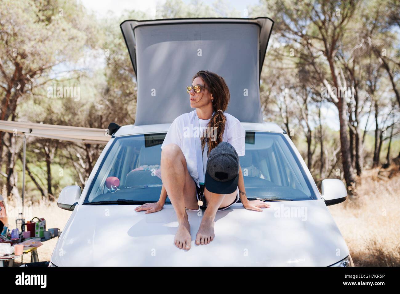 Woman sitting on camper van during vacation Stock Photo - Alamy