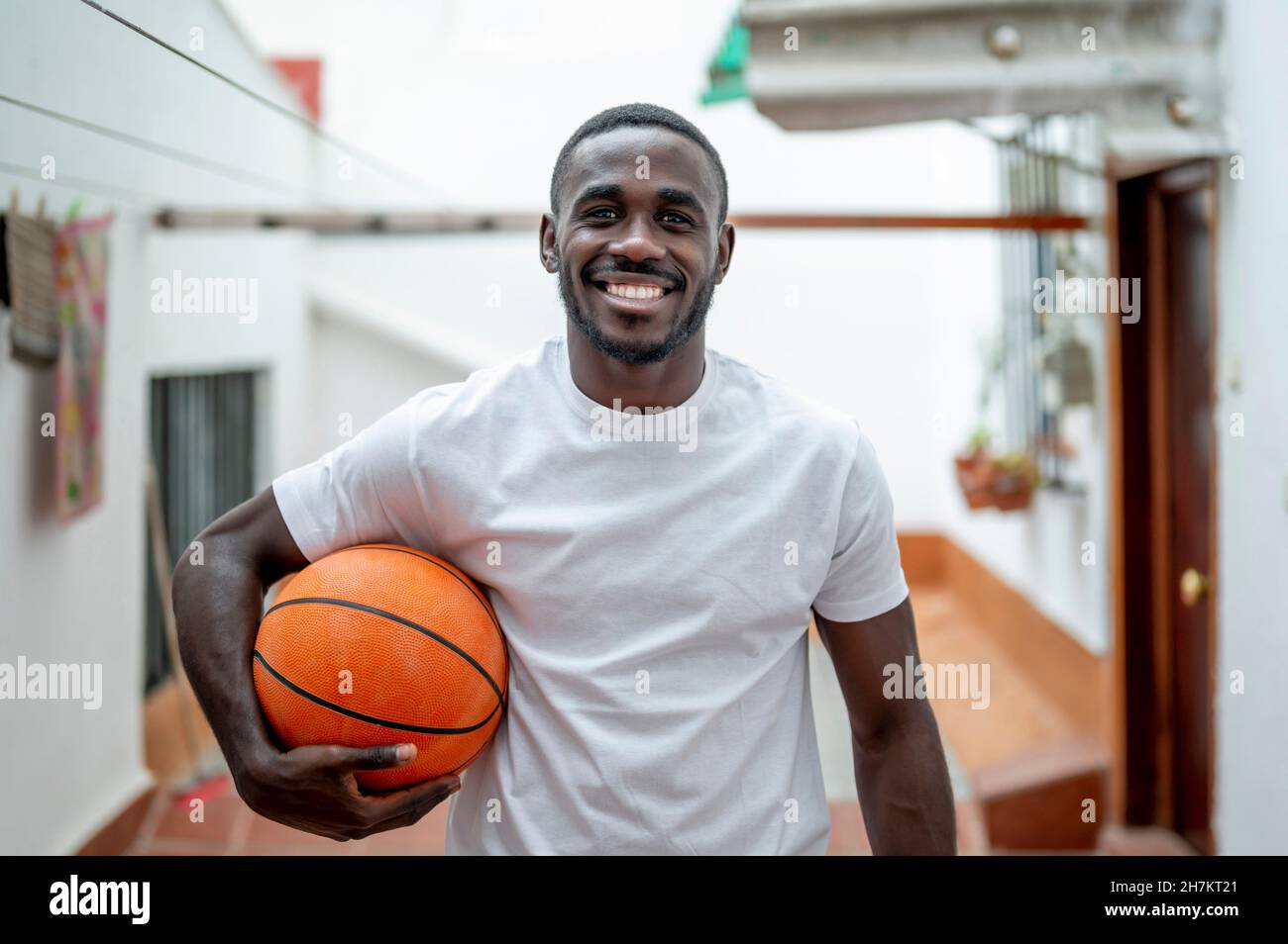 Man with basketball smiling Stock Photo - Alamy