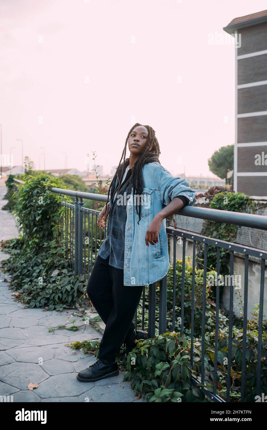 Thoughtful woman leaning on railing Stock Photo - Alamy