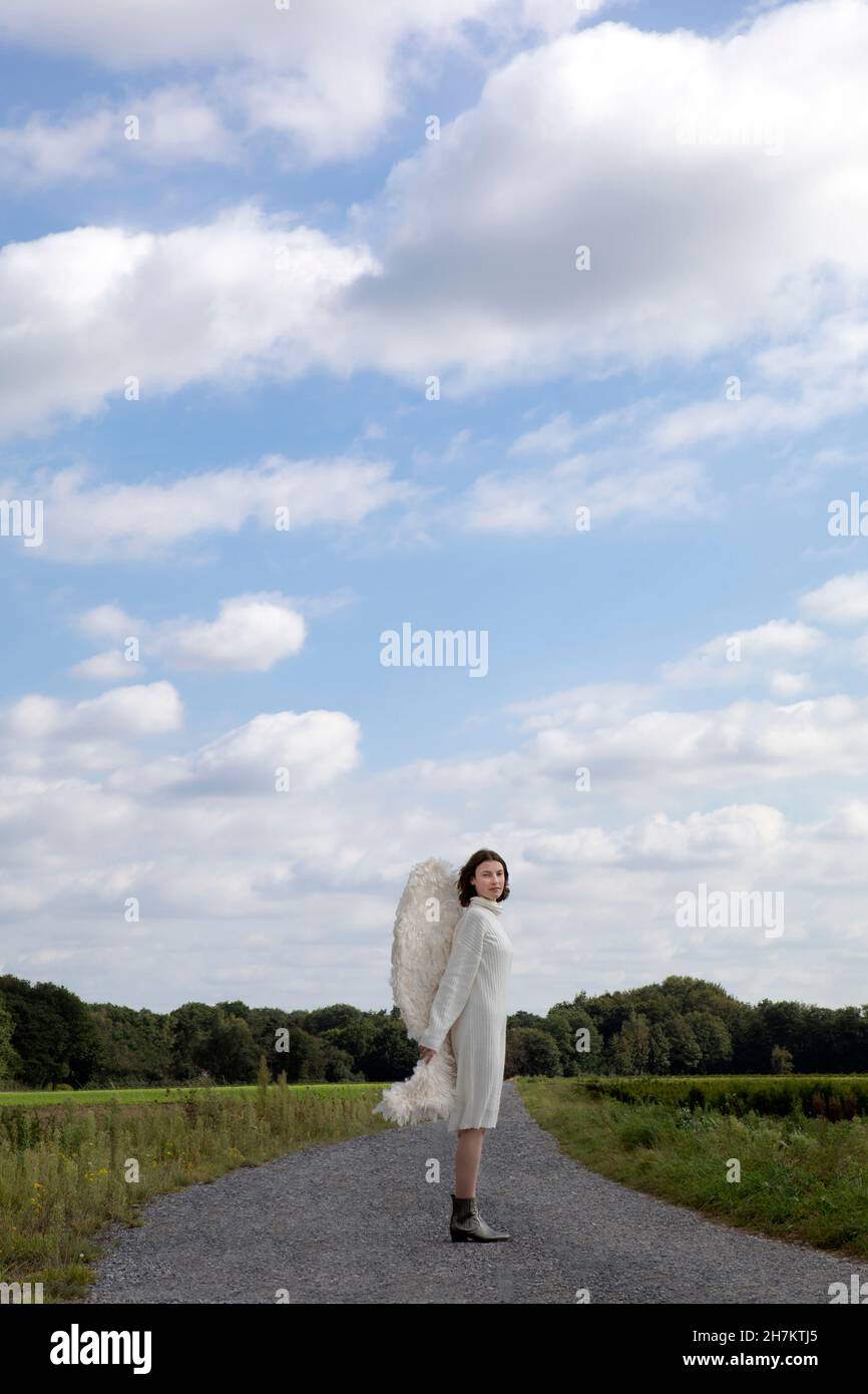 Girl wearing wings on road Stock Photo - Alamy