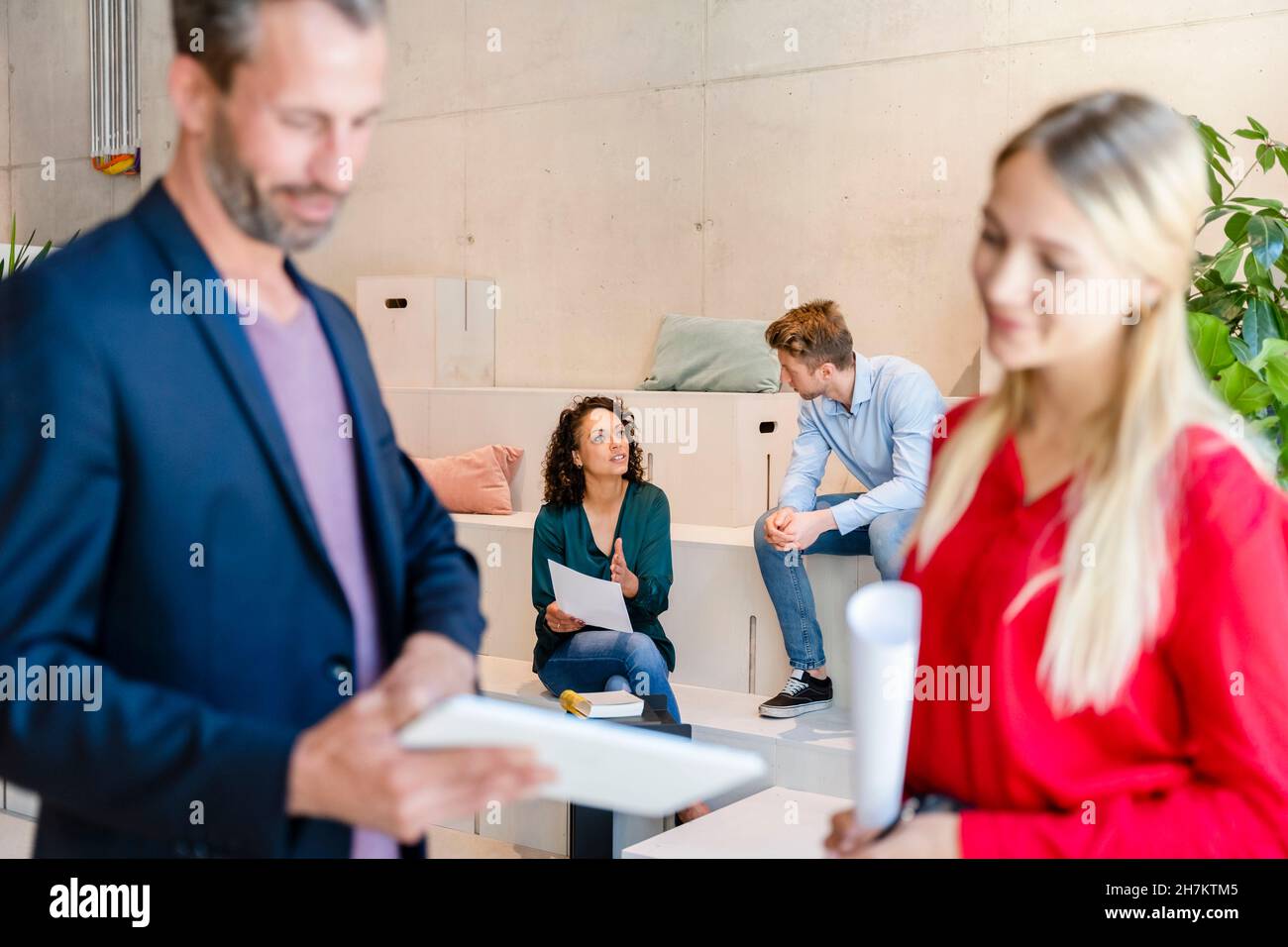 Colleagues having discussion at workplace Stock Photo - Alamy
