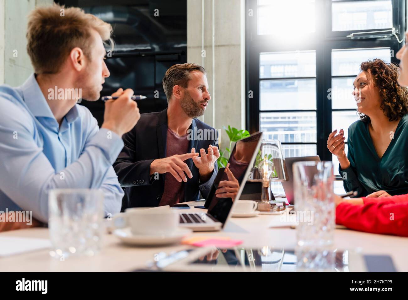 Employees having discussion at desk in meeting Stock Photo - Alamy