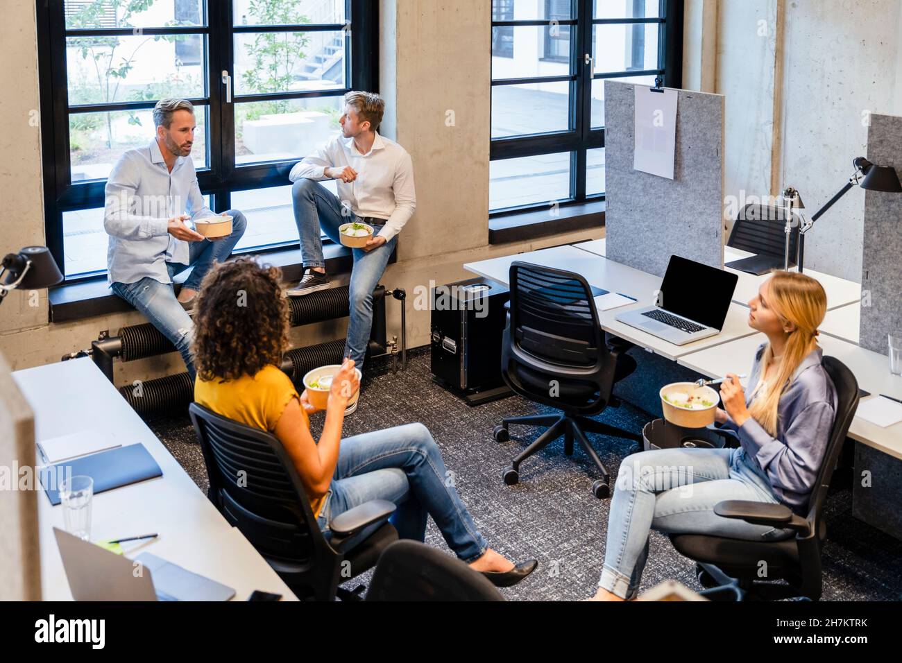 Employees having food at coworking office Stock Photo - Alamy