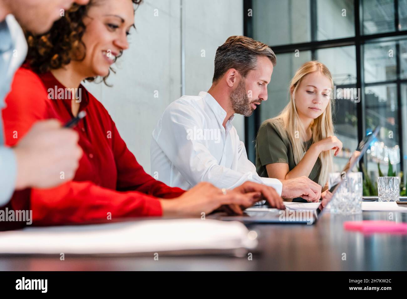 Employees working together in meeting at office Stock Photo - Alamy