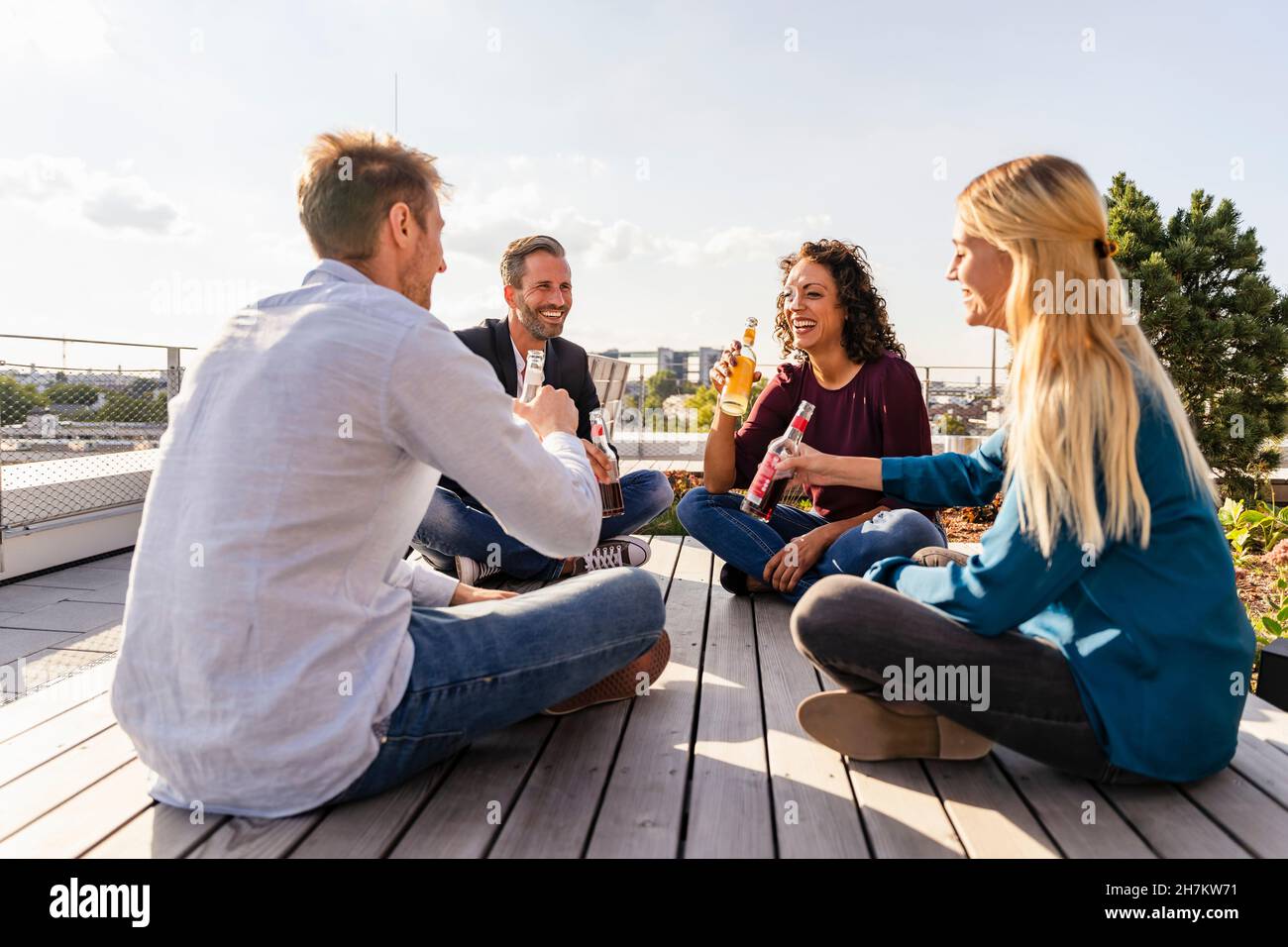 Happy colleagues toasting drinks on rooftop Stock Photo - Alamy