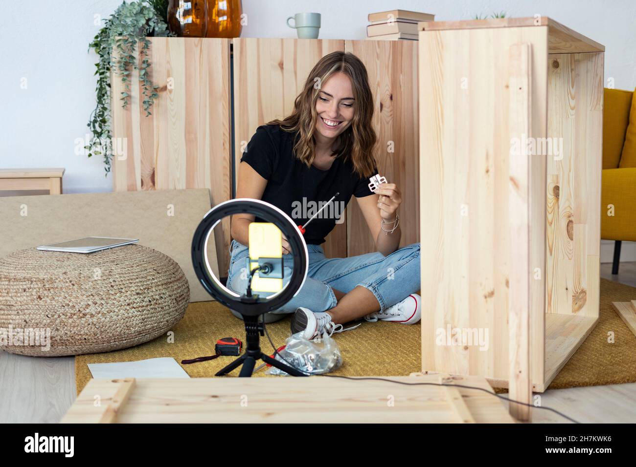 Smiling female influencer holding plank while vlogging at home Stock ...