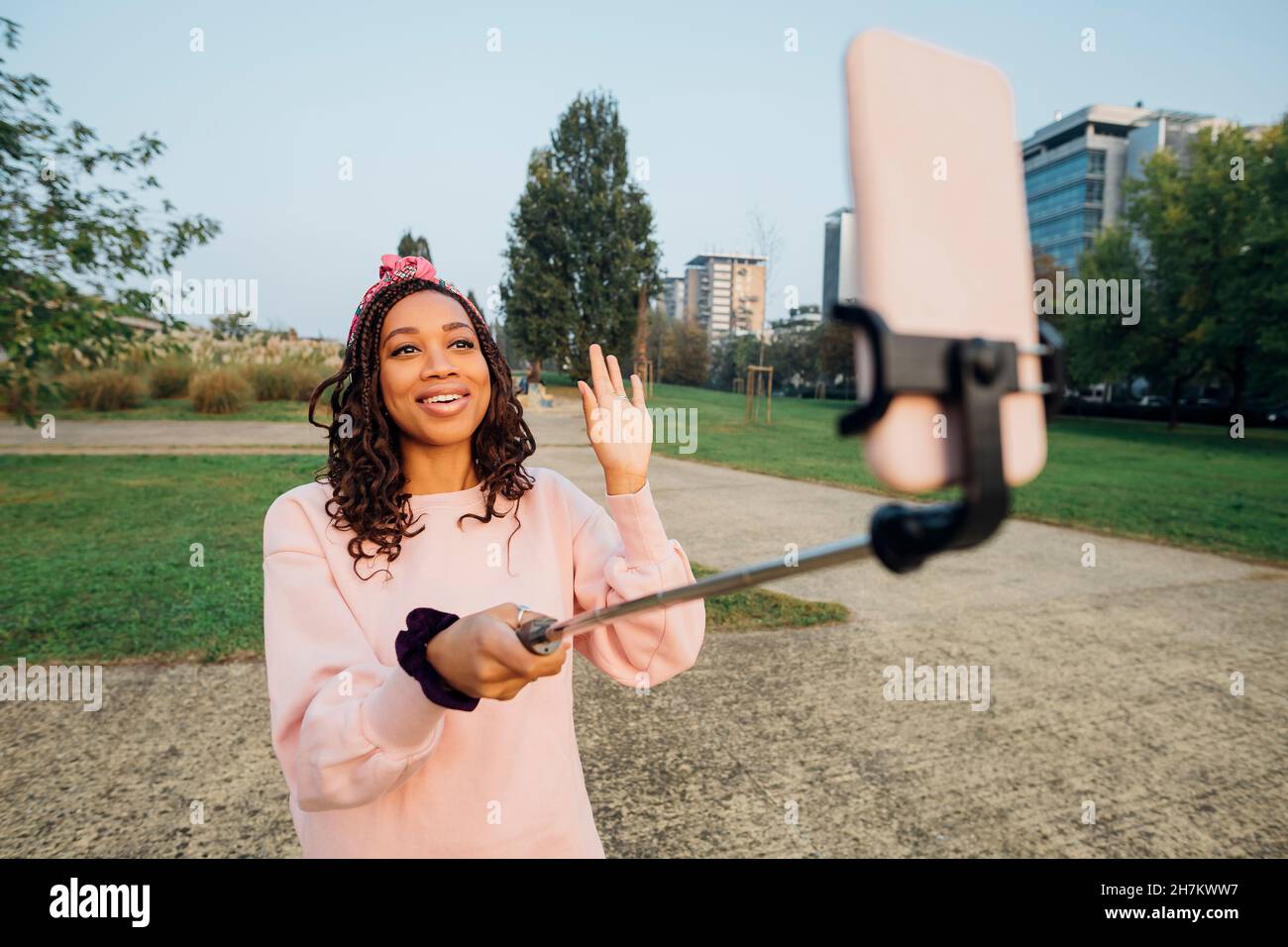 Woman waving hand while vlogging through smart phone at park Stock ...