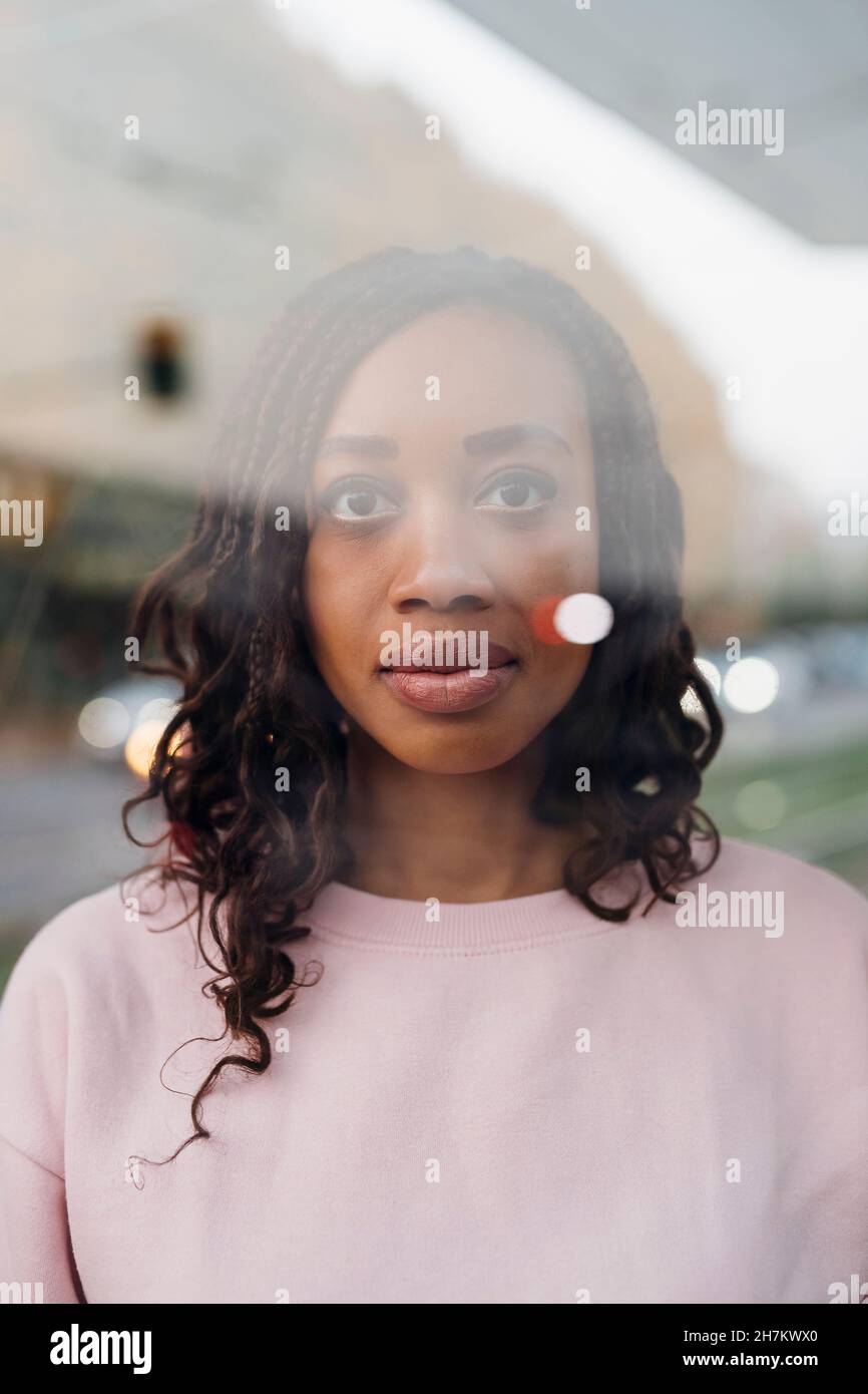 Woman looking through glass wall Stock Photo - Alamy