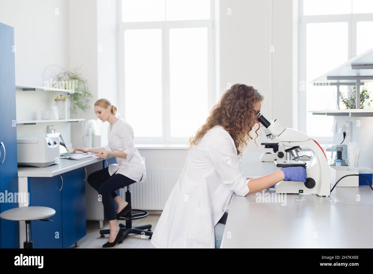 Medical laboratory scientist using microscope hi-res stock photography ...