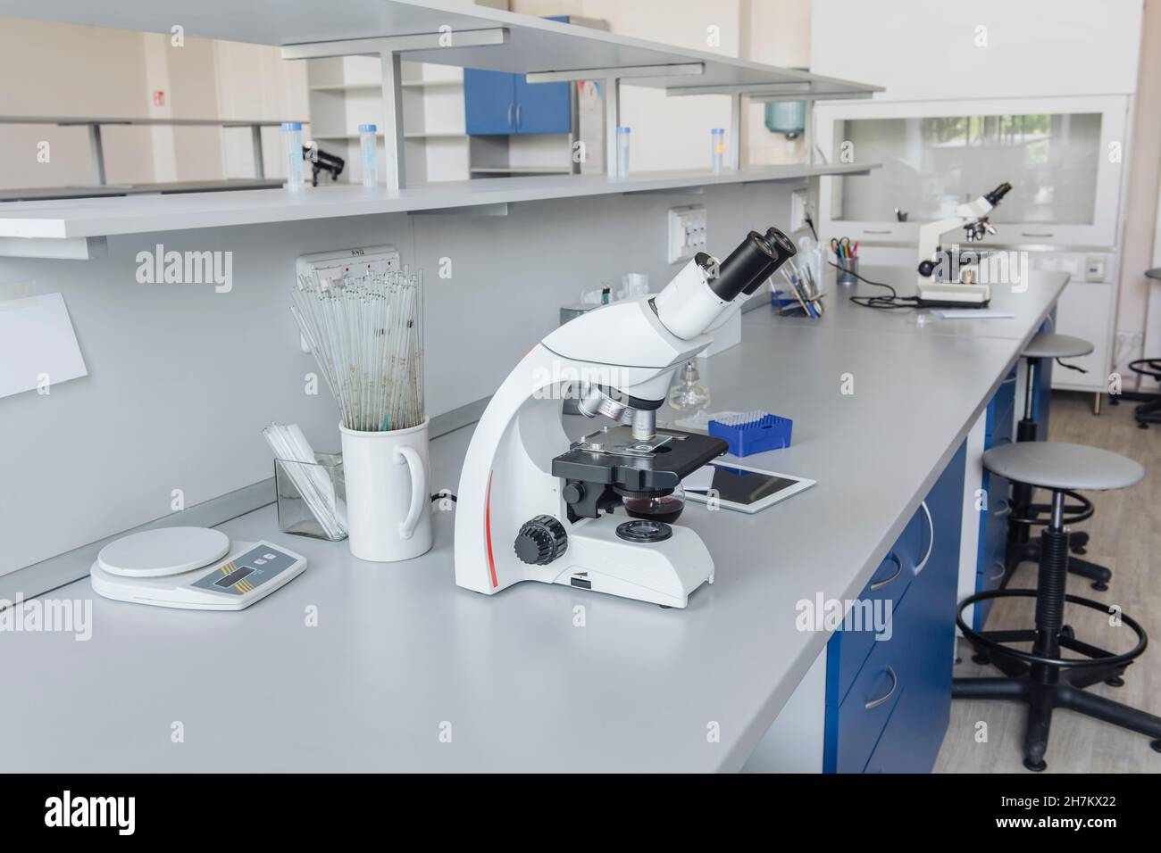 Microscope with medical equipment at desk Stock Photo - Alamy