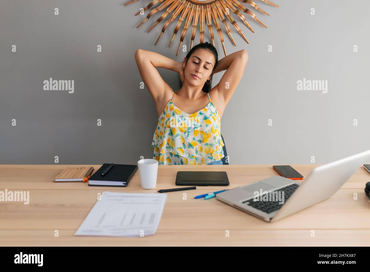 Working woman with arms raised relaxing at home Stock Photo - Alamy