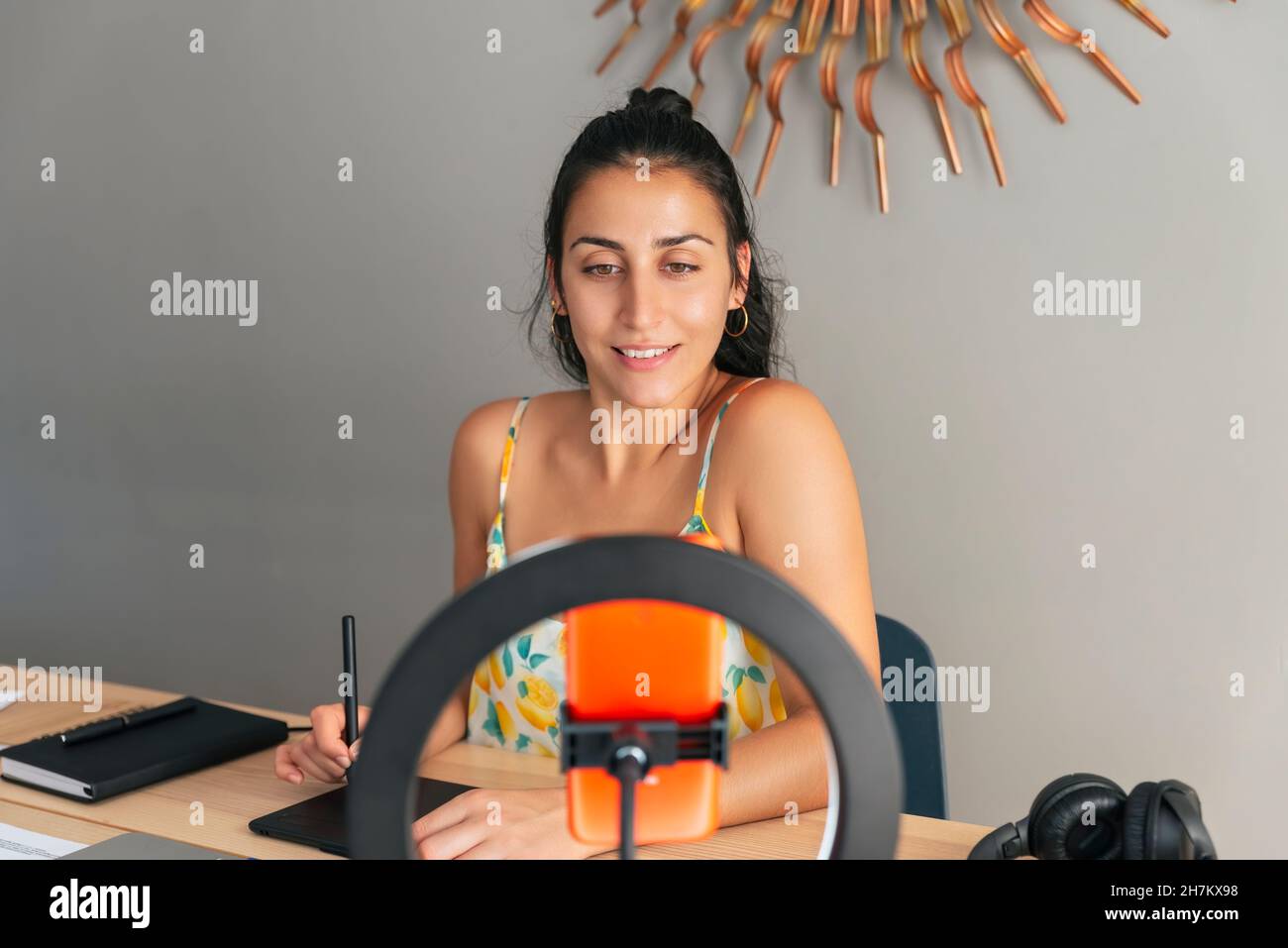 Smiling female influencer with digitized pen vlogging at home Stock ...