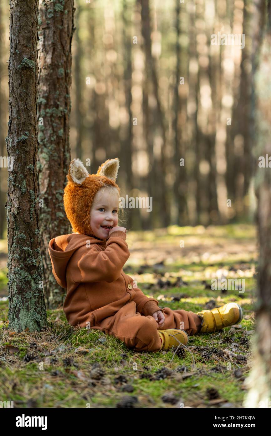 Cute girl smiling in front of tree trunk Stock Photo - Alamy