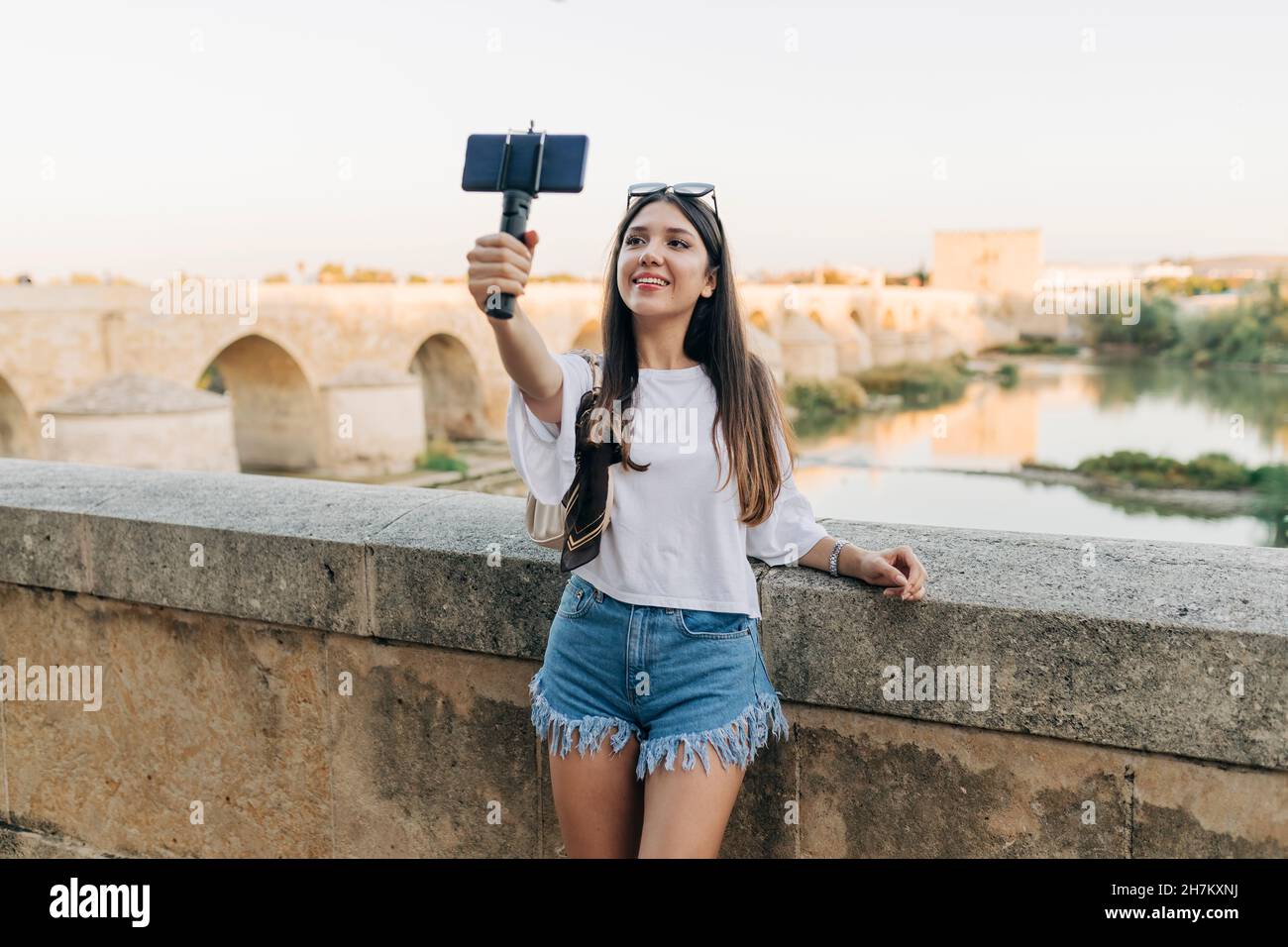 Young woman vlogging through smart phone near wall Stock Photo - Alamy