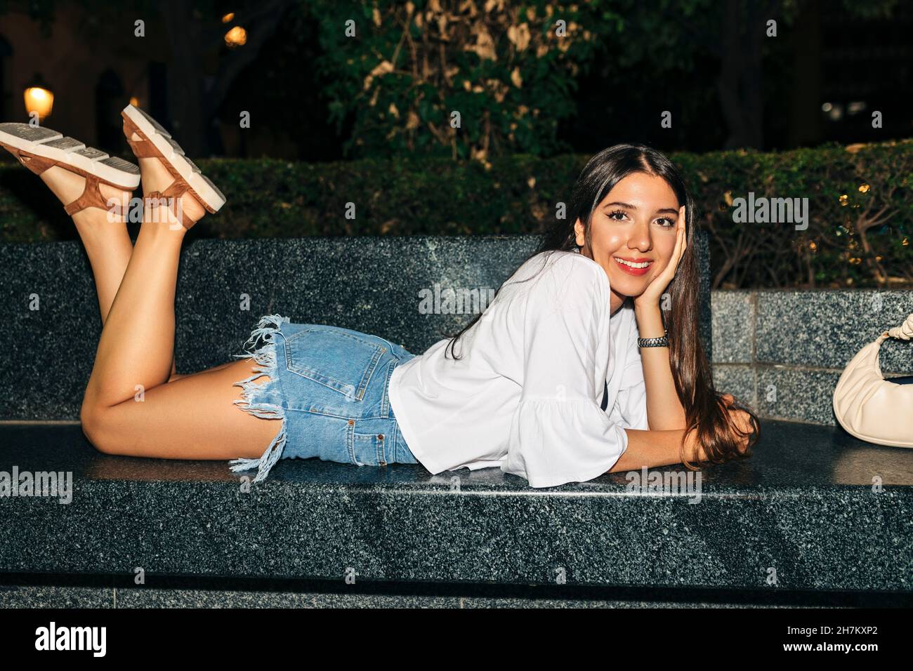 Beautiful woman lying on bench Stock Photo - Alamy
