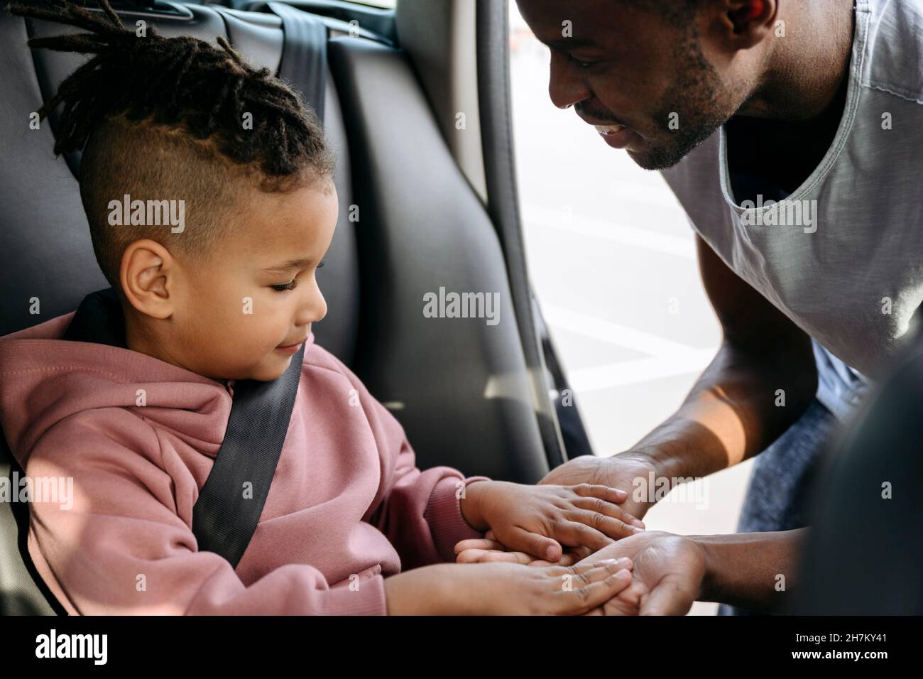 Son touching father's hands in car Stock Photo - Alamy