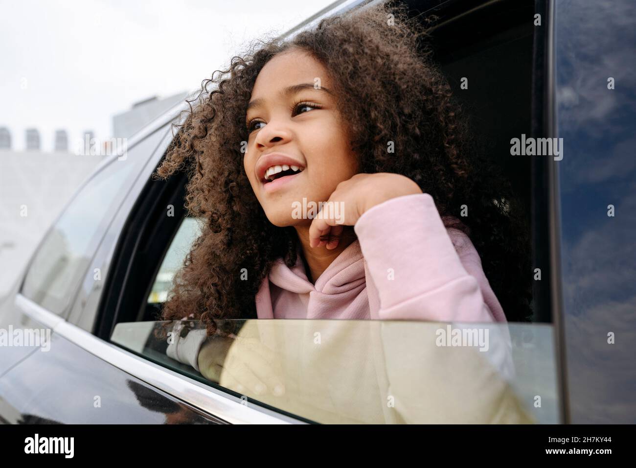 Smiling girl looking out of car window Stock Photo - Alamy