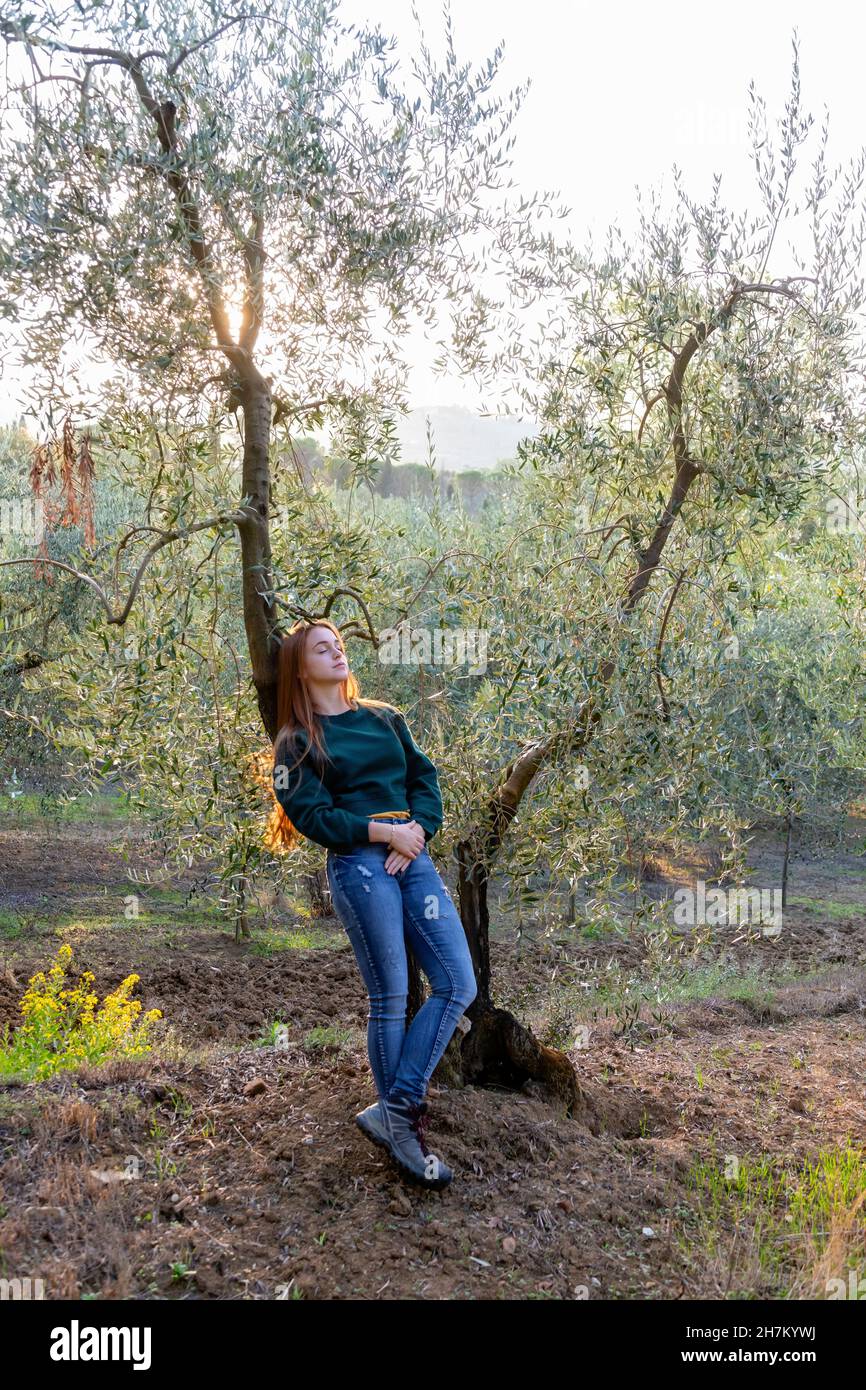 Woman with eyes closed leaning on tree trunk at countryside Stock Photo ...