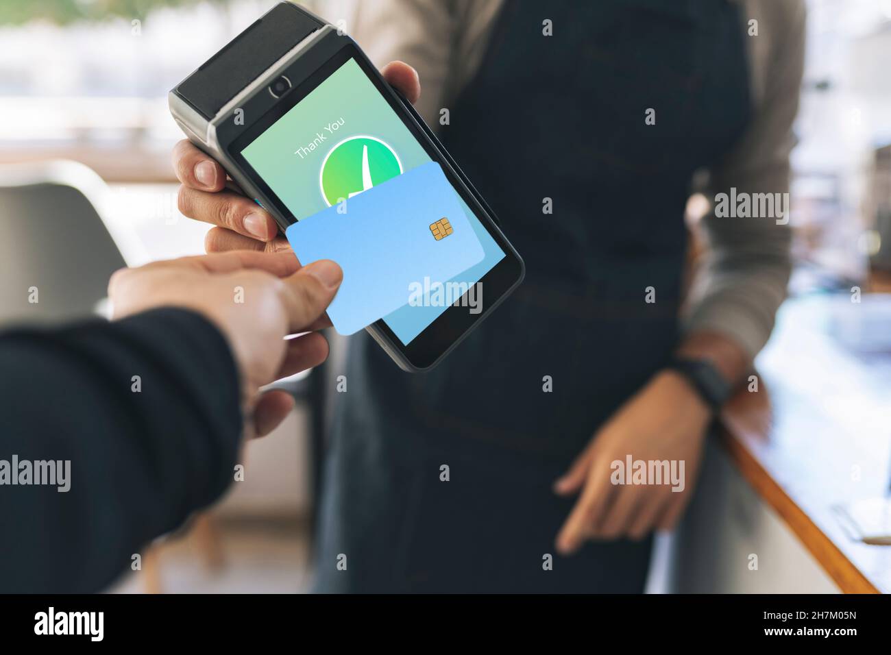 Waiter pointing at credit card reader screen in cafe Stock Photo - Alamy