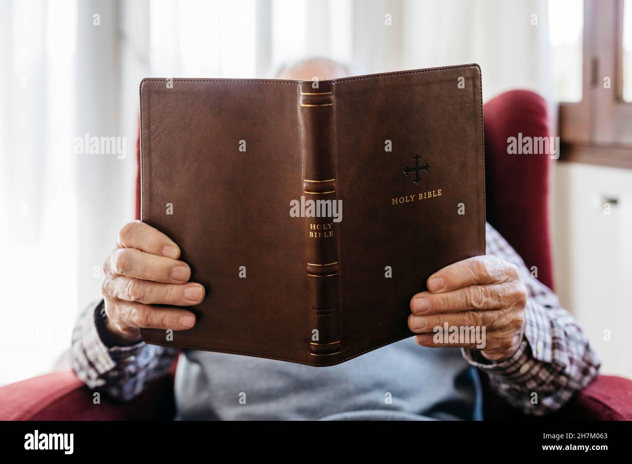 Senior man reading bible at home Stock Photo - Alamy