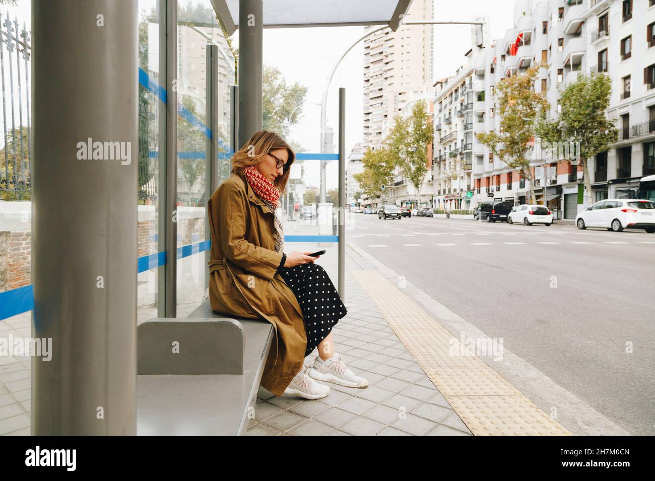 Woman smartphone waiting bus stop hi-res stock photography and images ...