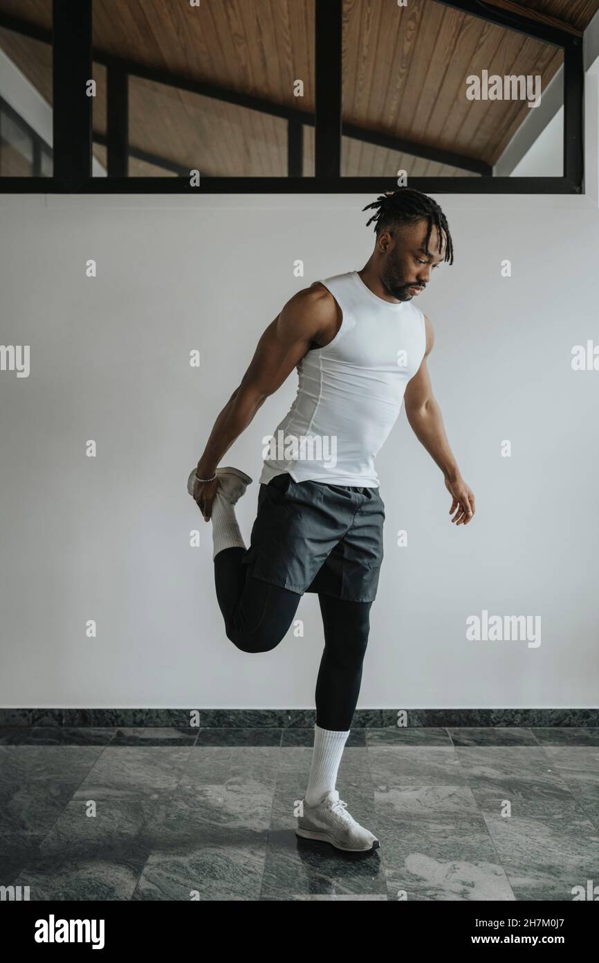 Fit young man stretching leg Stock Photo - Alamy