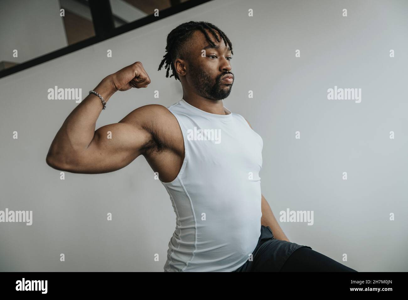 Young man flexing muscles exercising hi-res stock photography and ...