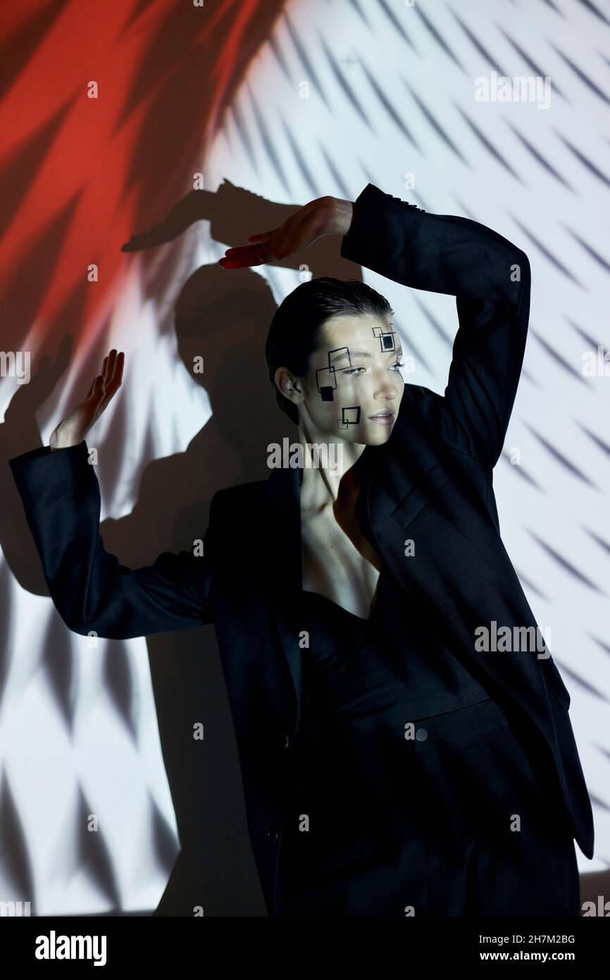 Teenage girl with creative makeup and projector's light against white ...