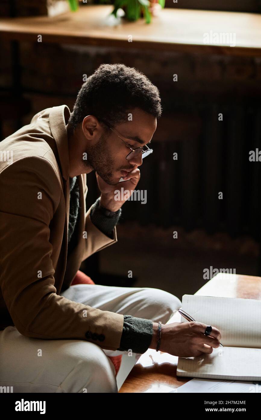 Mixed race man writing notes hi-res stock photography and images - Alamy
