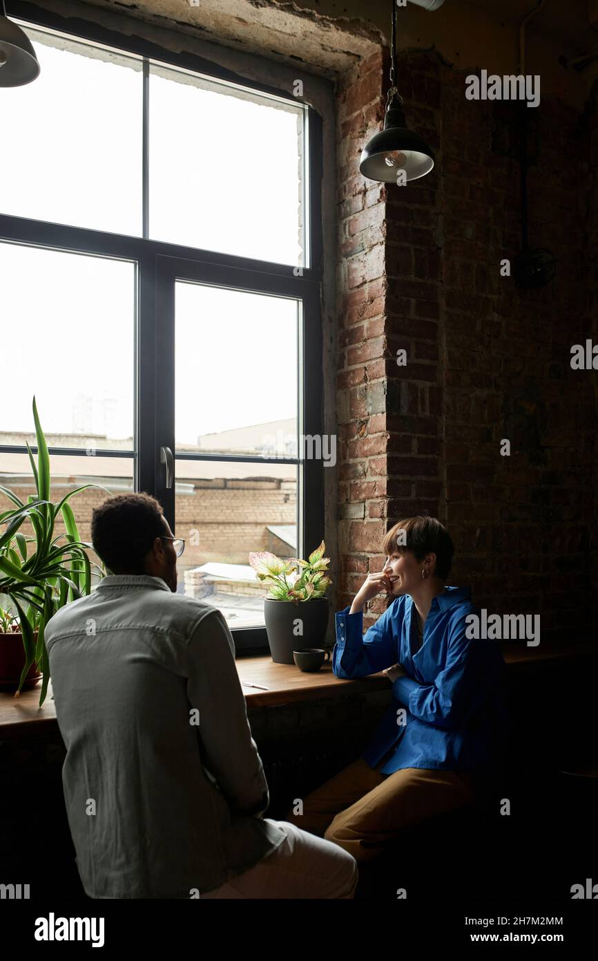 Couple talking at window in cafe Stock Photo - Alamy
