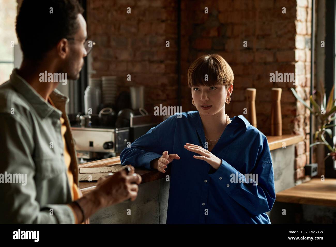 Teenage girl gesturing and talking with boyfriend in cafe Stock Photo ...