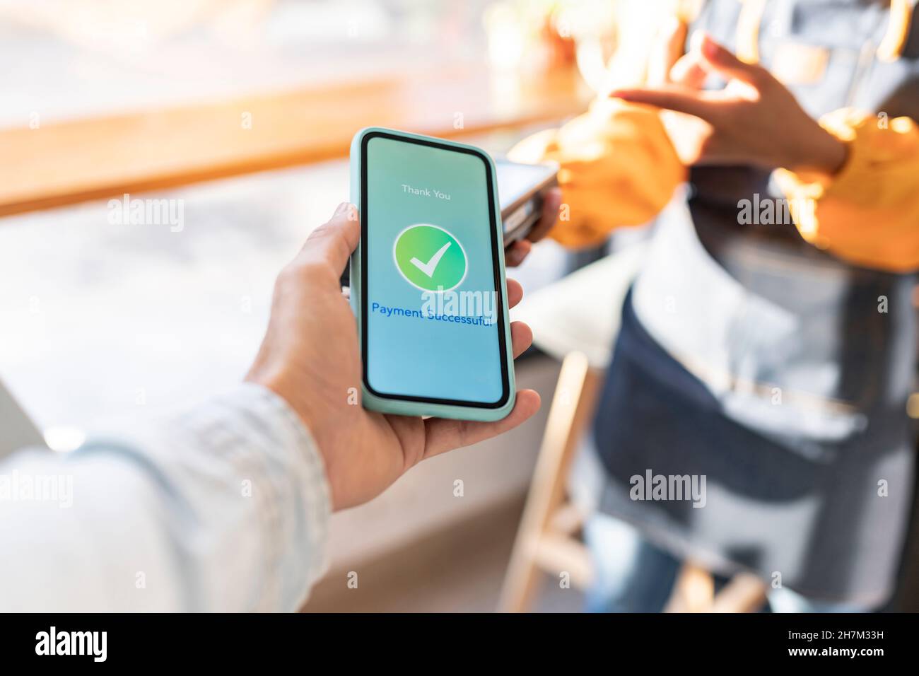 Customer with check mark paying through mobile phone in cafe Stock ...