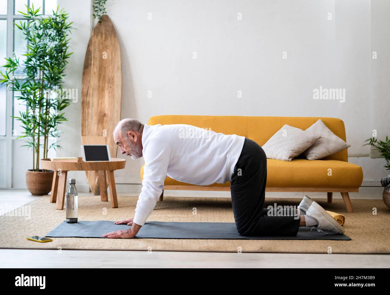 Active senior man with feet up exercising in living room at home Stock ...