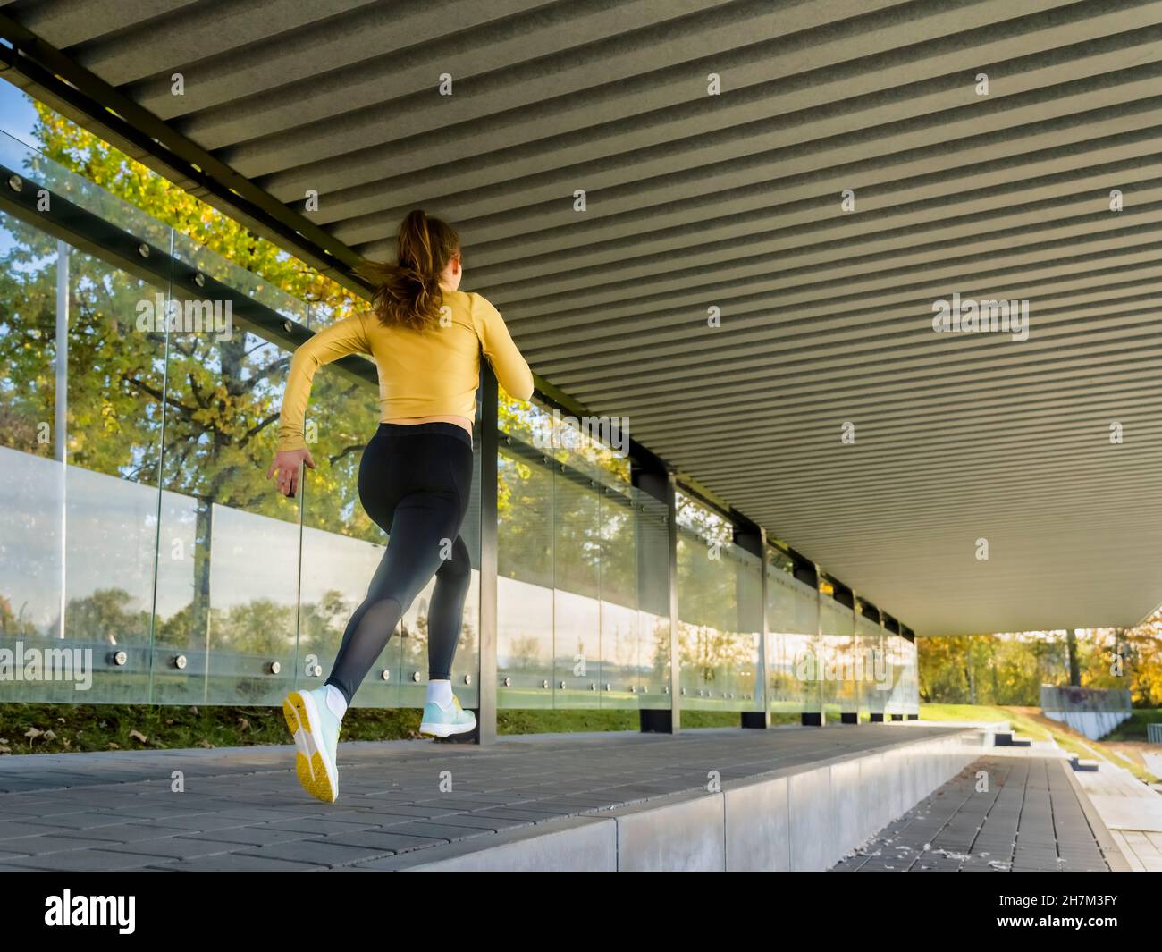 Female teenager jogging under building canopy Stock Photo - Alamy