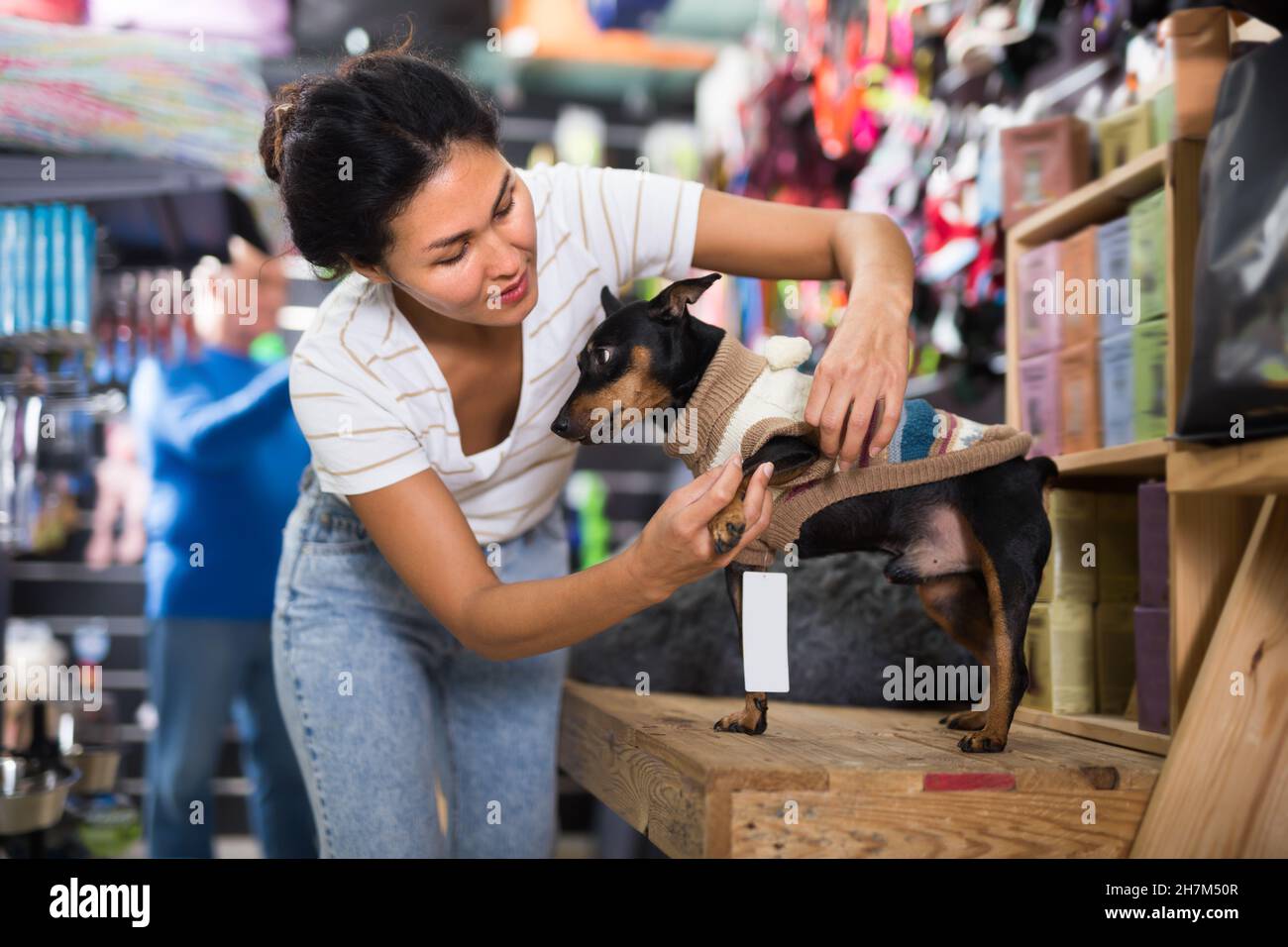 Woman dressing her dog in pet shop Stock Photo - Alamy