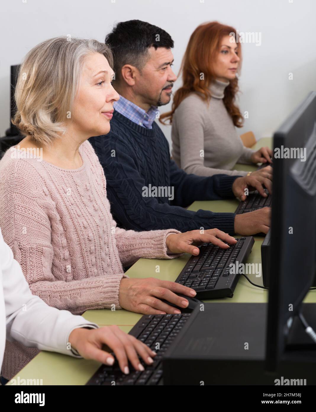Side view of coworkers during daily work at computers in office Stock ...