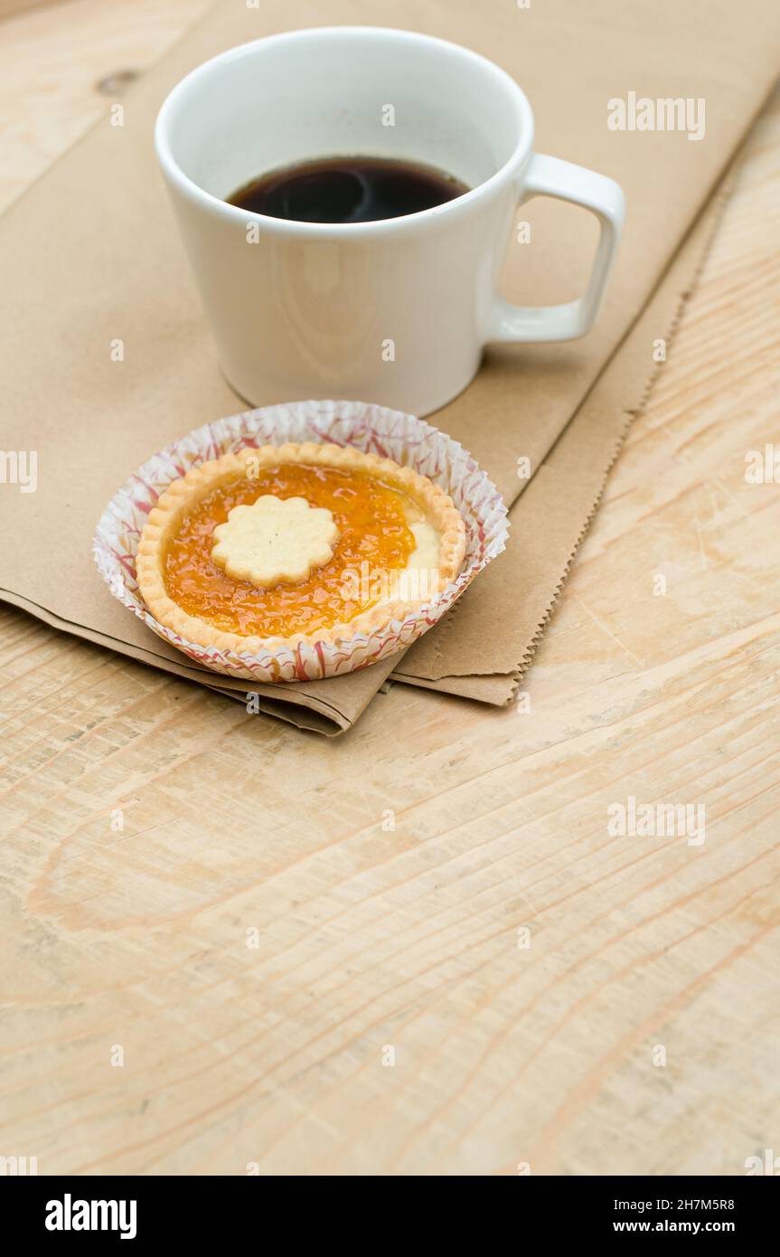 delicious jam short crust pastry and black coffee cup on a food paper ...